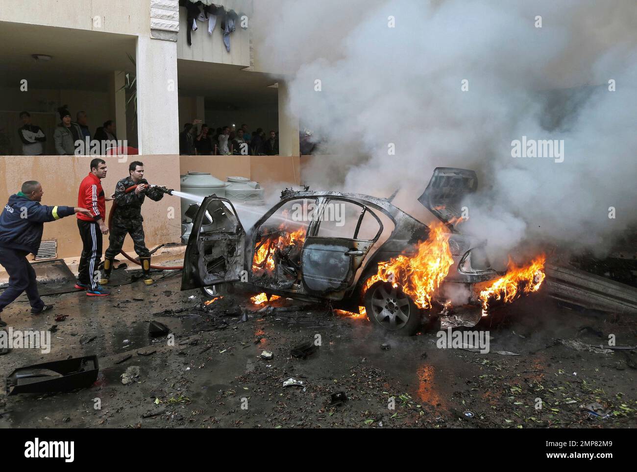 Firefighters extinguish a burning car that was destroyed in a bombing ...