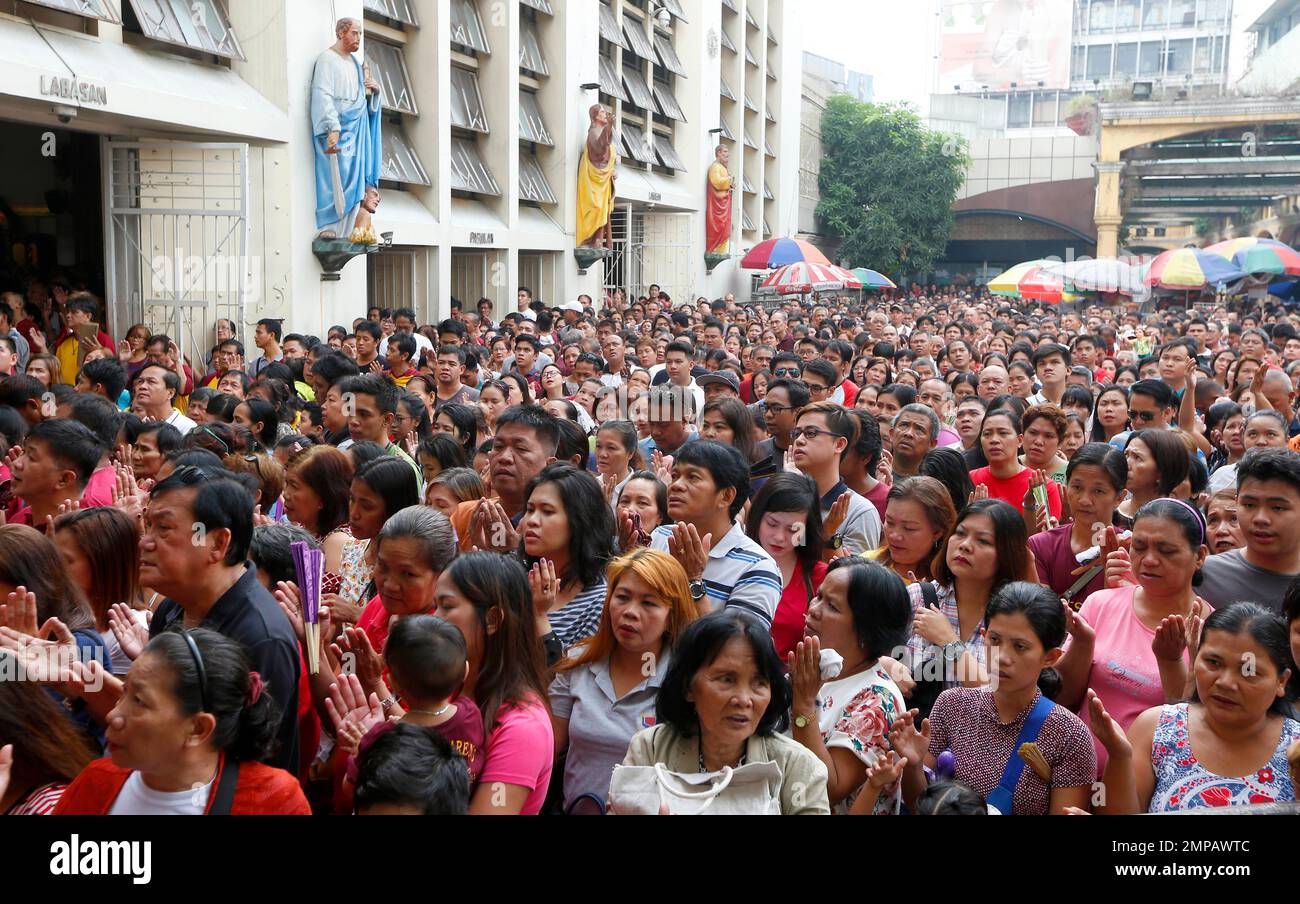 Hundreds of Filipino Roman Catholic devotees pray as they attend the ...