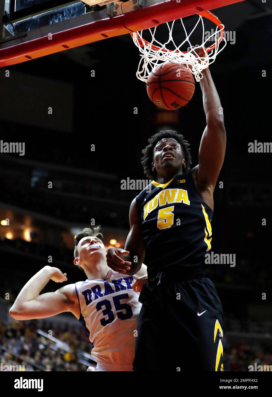 Iowa forward Tyler Cook (5) dunks the ball ahead of Drake forward Nick ...