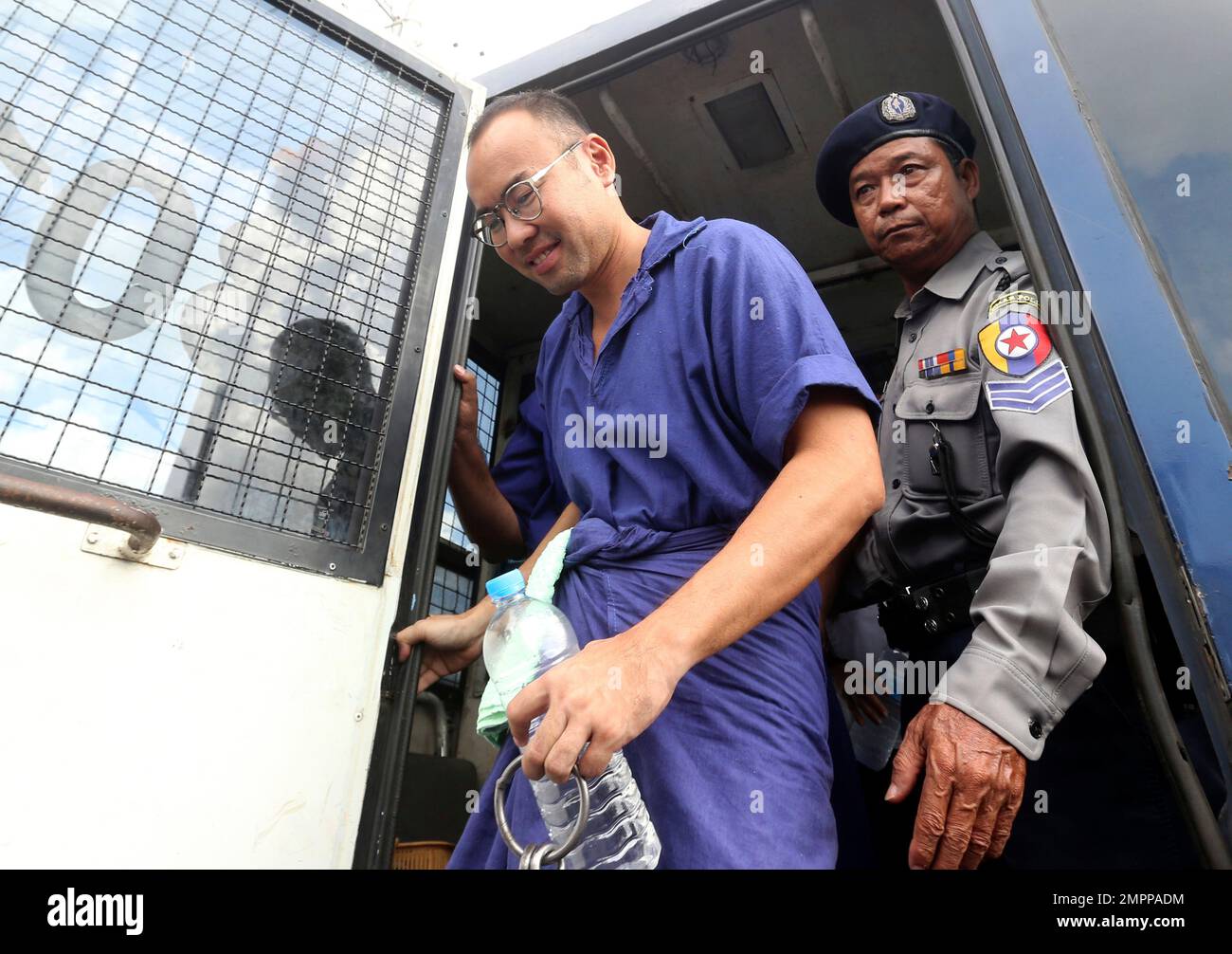 Singaporean journalist Lau Hon Meng gets off a police van before his ...