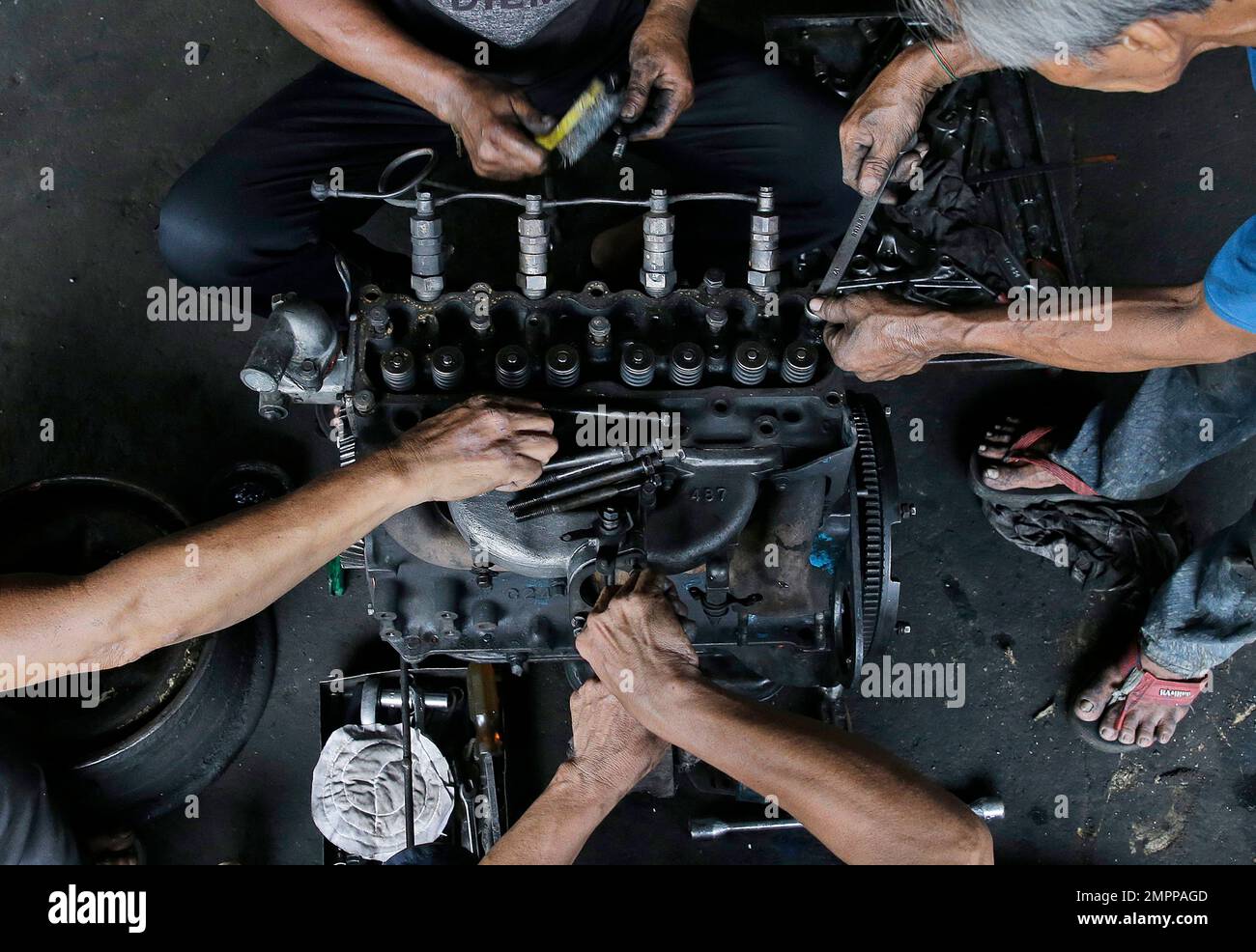 In this Sept. 22, 2017, photo, Filipinos work on an old diesel engine ...