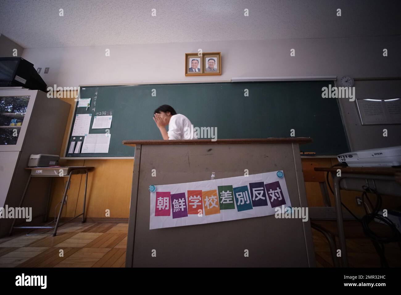 In this Sept. 26, 2017, photo, a student walks below the portraits of ...