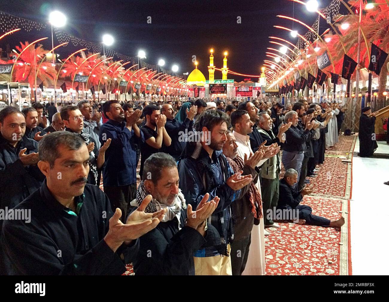 Shiite faithful pilgrims pray in front of the holy shrine of Imam ...