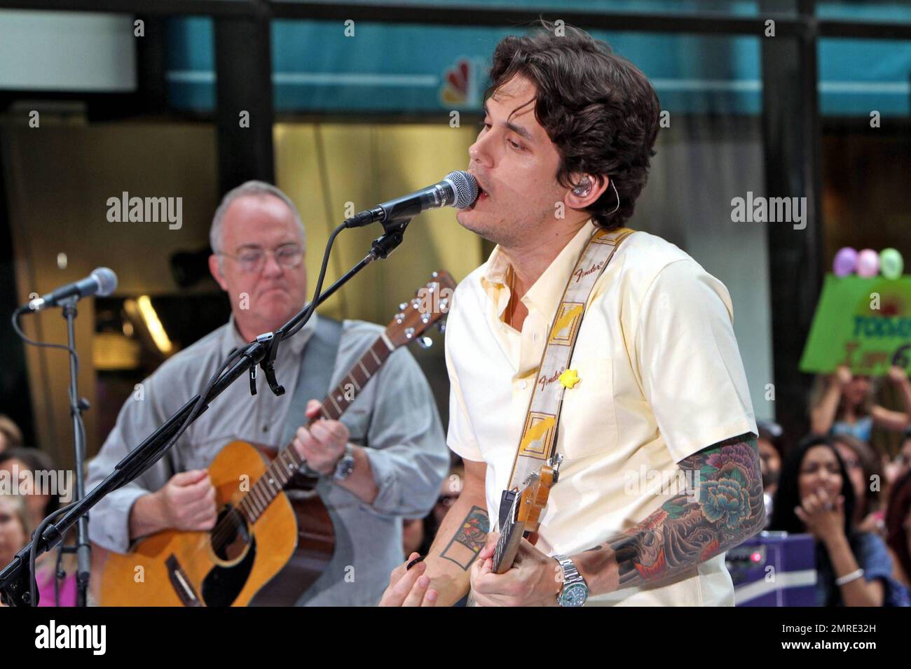 John Mayer sieht für den Sommer in einem blassgelben Hemd und einer ...