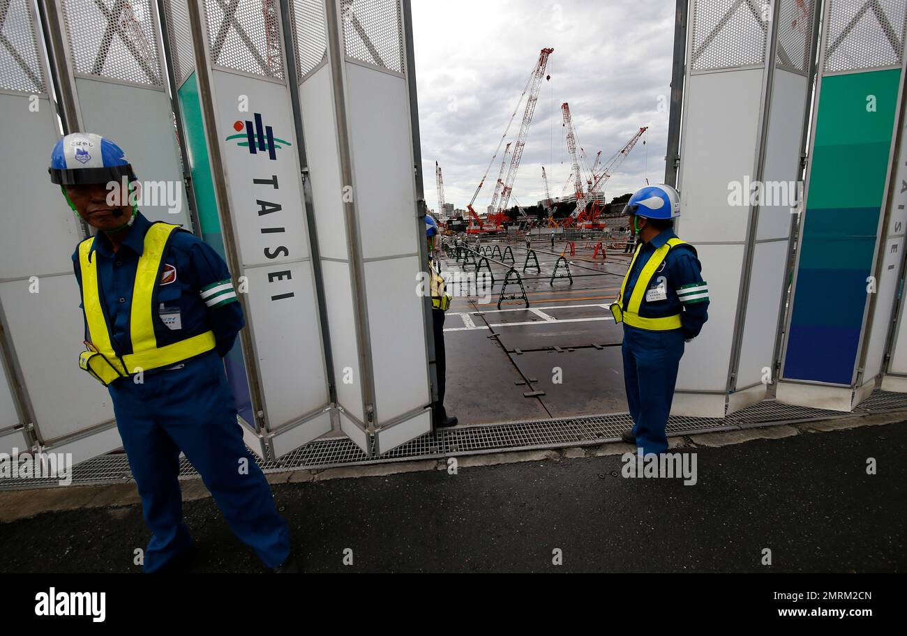 Security guards stand in front of a gate of a construction site of new ...