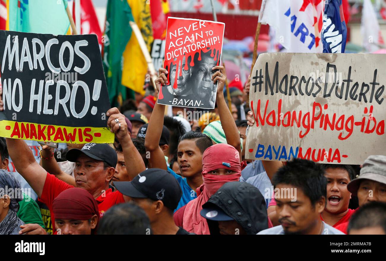 Protesters display placards during a rally near the gates of the Heroes ...
