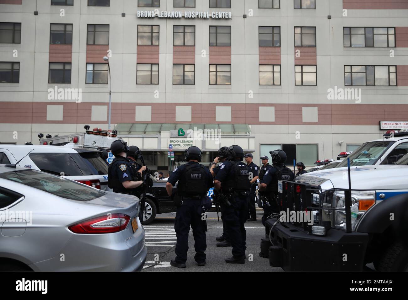 A heavily armed police officers stands outside Bronx Lebanon Hospital ...