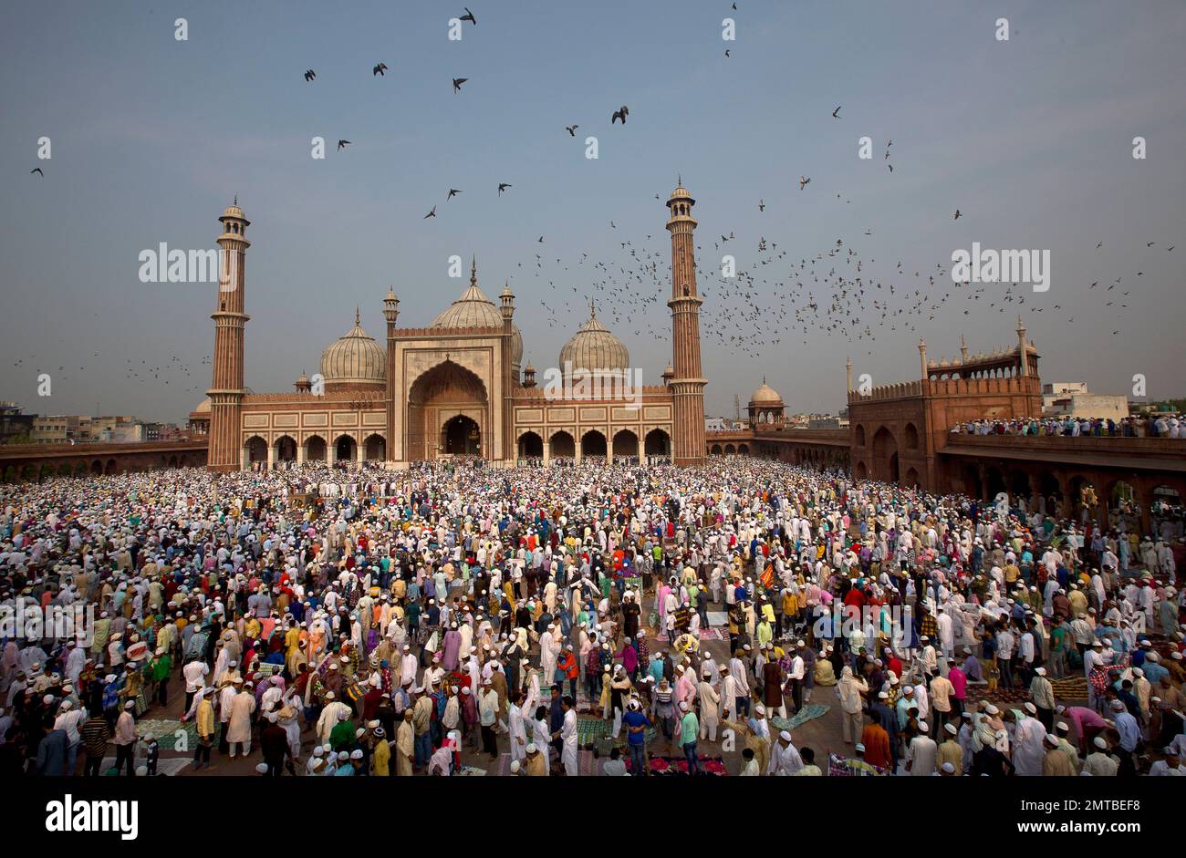 Muslims hug and greet each other after offering Eid al-Fitr prayers at ...