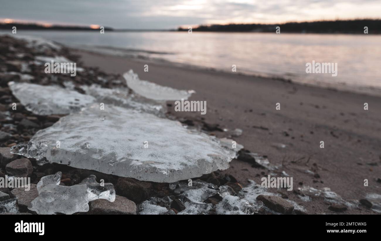 Kleine Eisschollen des ersten Eiss liegen am Sandufer des Vilyui River ...