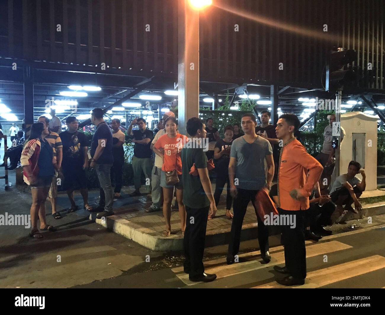 Employees and onlookers gather outside the Resorts World Manila complex ...