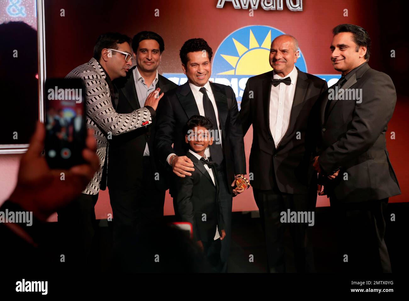Former Indian cricketer Sachin Tendulkar, center, poses for photographs ...