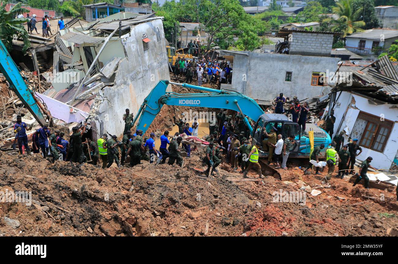 Sri Lankan government soldiers and rescue workers cary a body recovered from site of a garbage ...