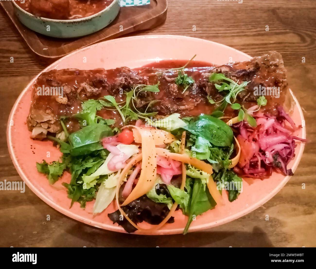 Blick von oben auf argentinisches Schweinerippchen mit farbenfrohem ...
