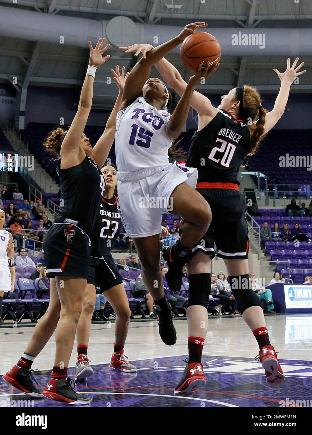 TCU forward Jada Butts (15) goes up for a shot between Texas Tech's ...