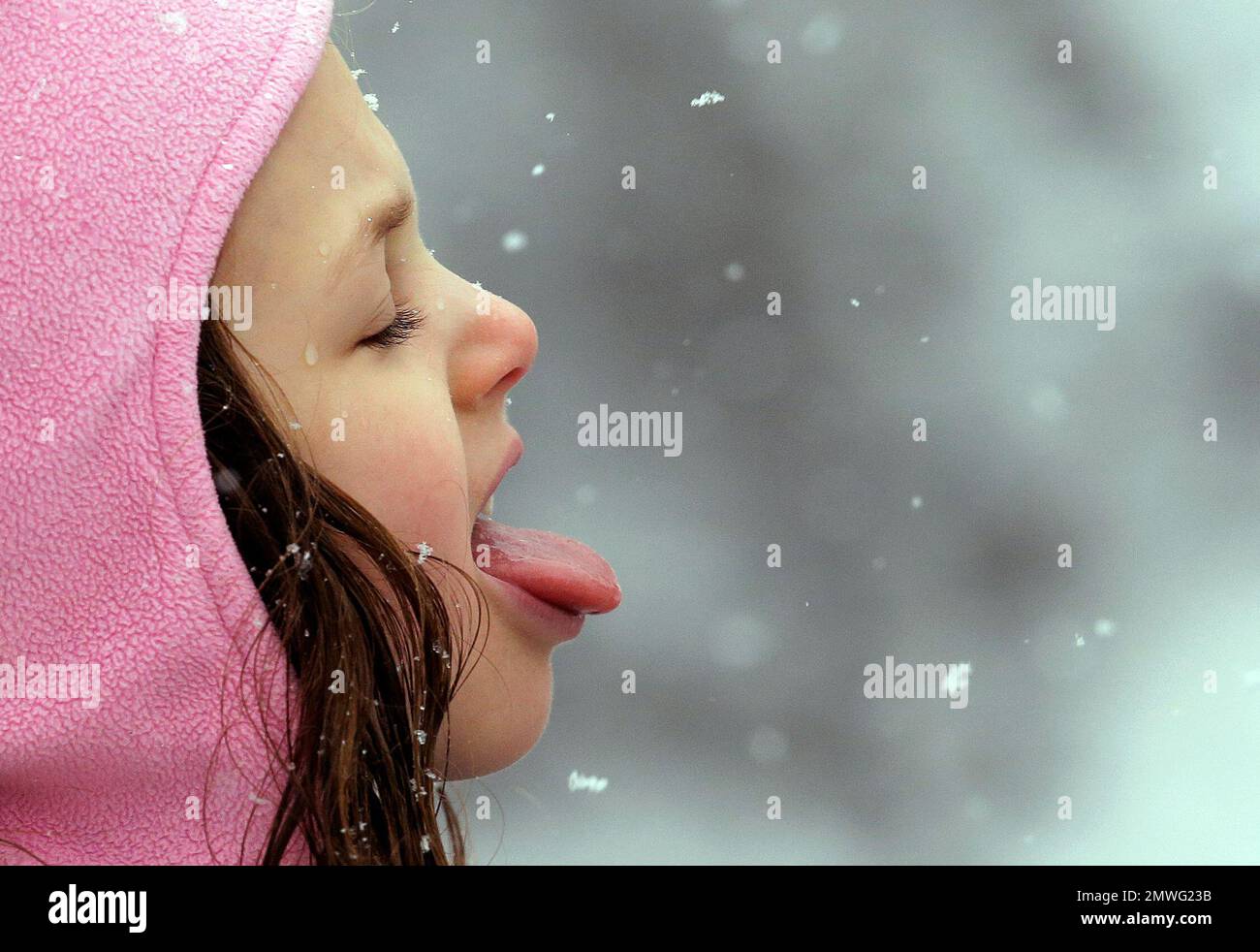Penny Austin, 5, tries to catch snowflakes on her tongue during a ...
