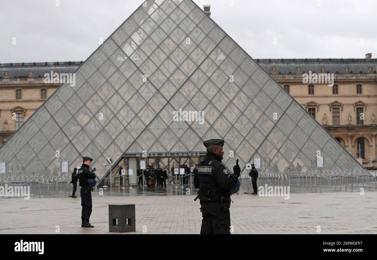 Armed police officers patrol in the courtyard of the Louvre museum near ...