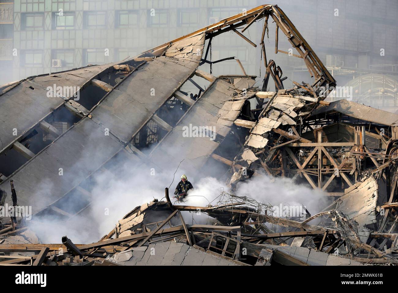 Iranian firefighters work at the scene of the collapsed Plasco building ...
