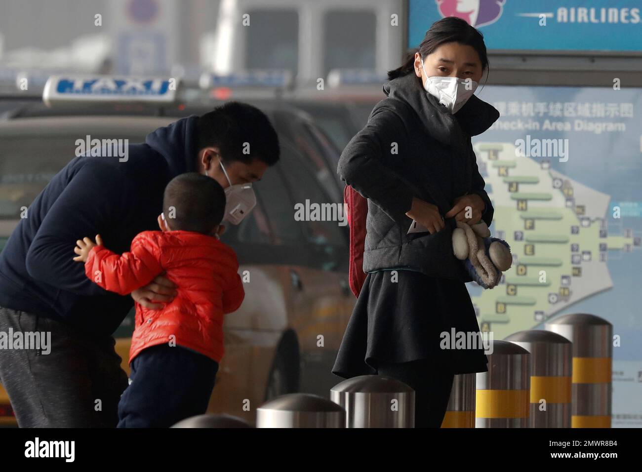 A Chinese couple and a child wearing masks for protection against air ...