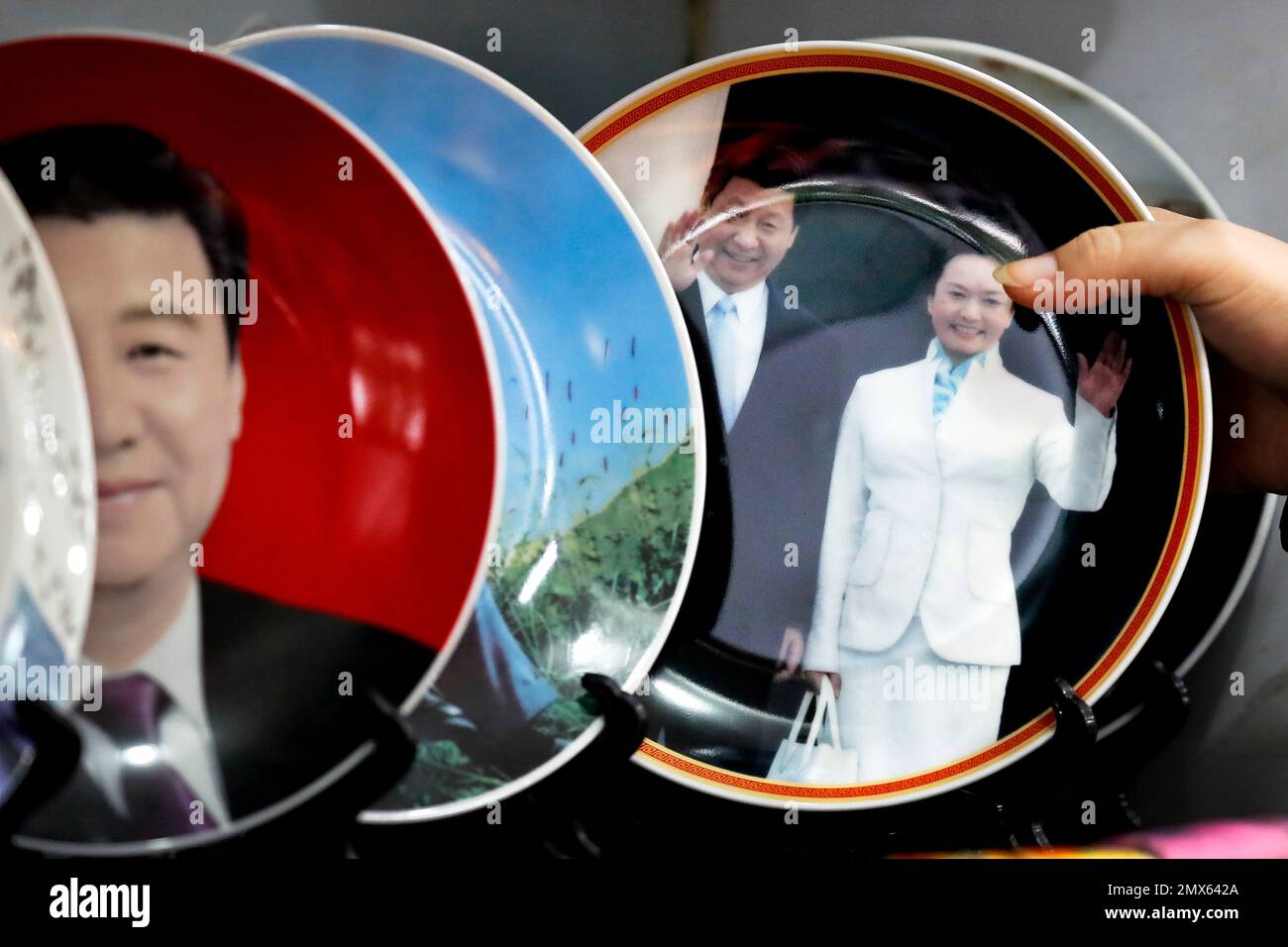 A worker places a porcelain plate baring an image of Chinese President ...