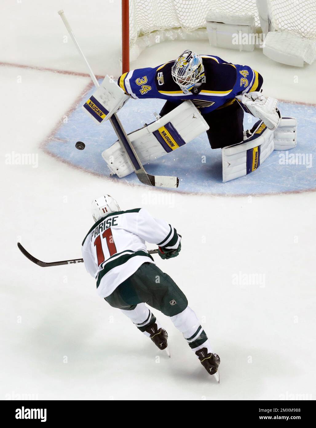 St. Louis Blues goalie Jake Allen, top, deflects a shot from Minnesota ...