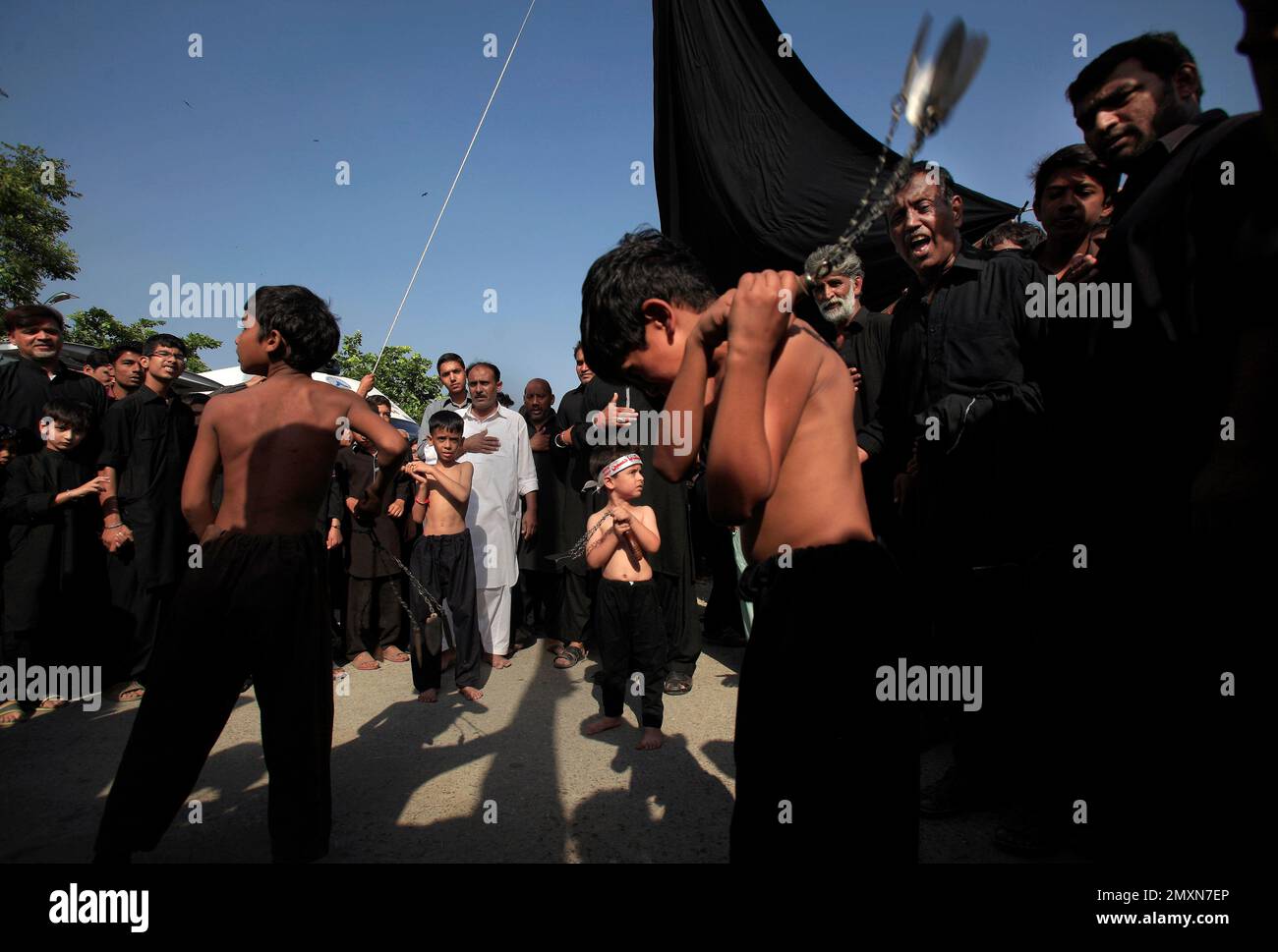 Pakistani Shiite Muslim children beat themselves with knives attached ...