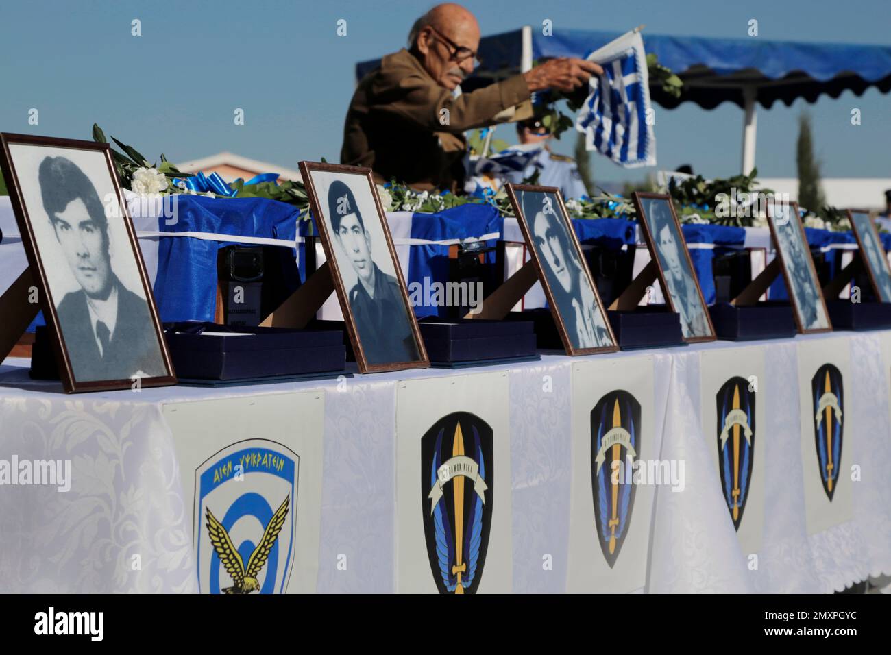 An elderly man leaves Greek and Cypriot flags on the coffins of the ...