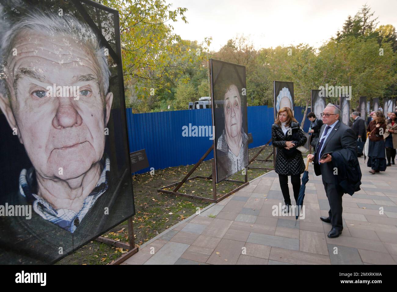 Visitors pass by portraits of victims of Nazi concentration camps ...