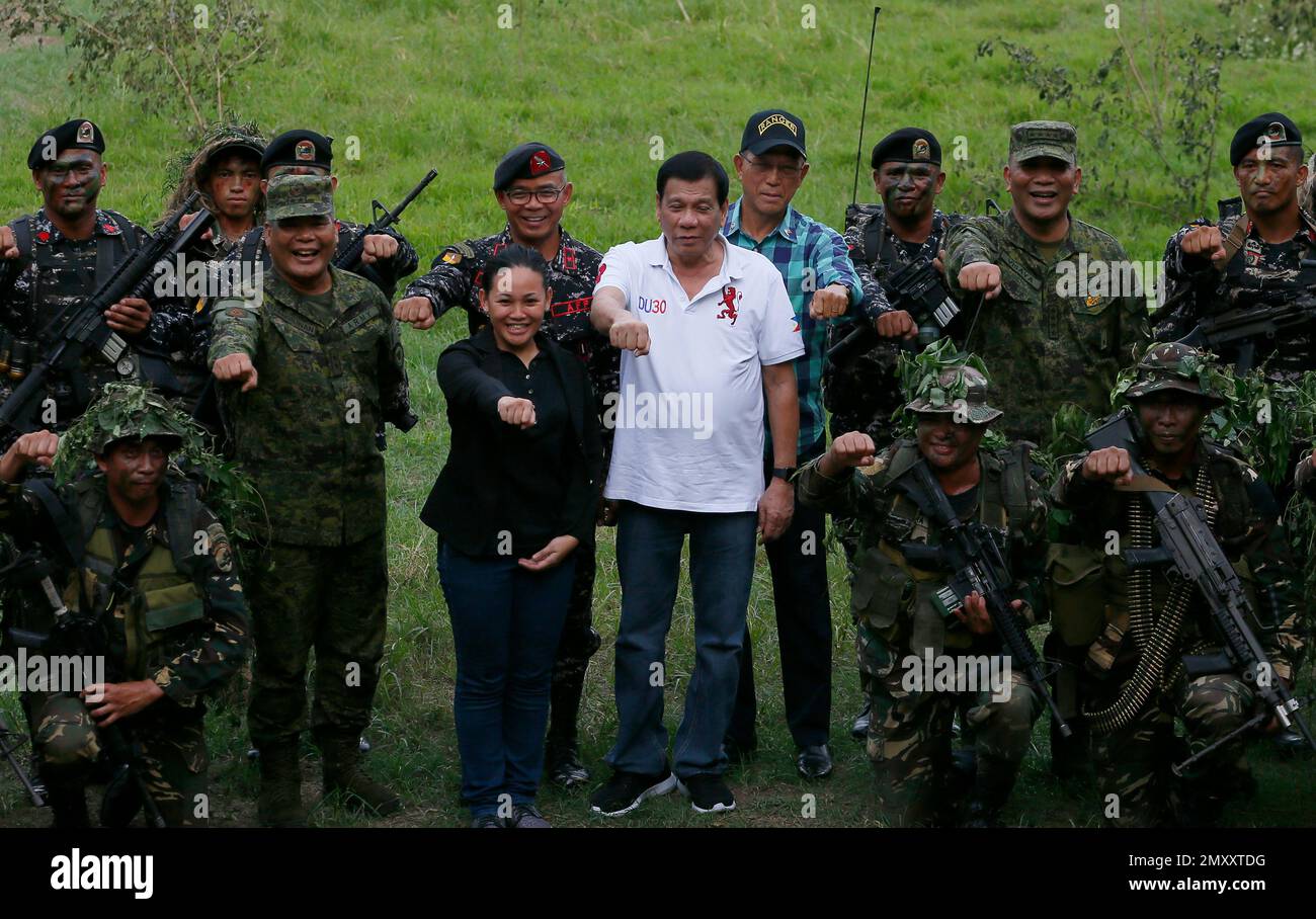 Philippine President Rodrigo Duterte, center, gestures with a fist bump ...