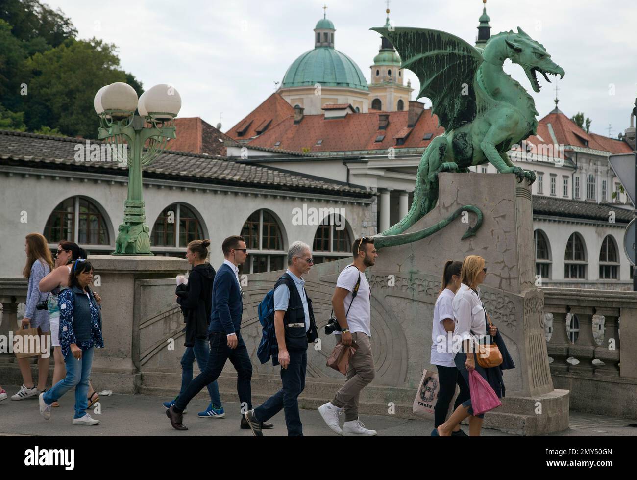 In this Aug. 12, 2016 photo, tourists and residents walk by a statue of ...