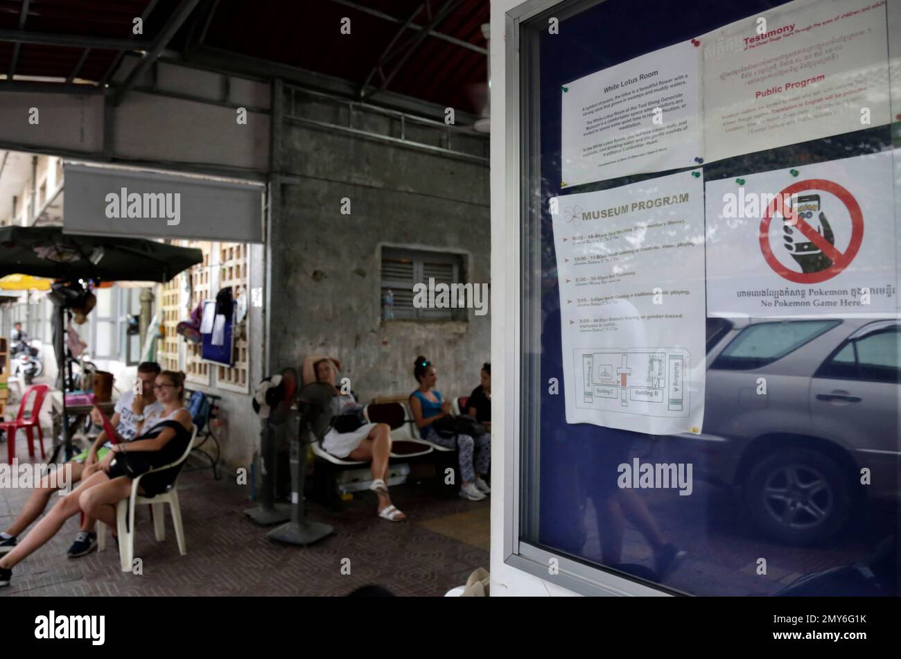 A warning sign, right, reads "No Pokemon Game" is stuck at a front gate of Tuol Sleng genocide ...