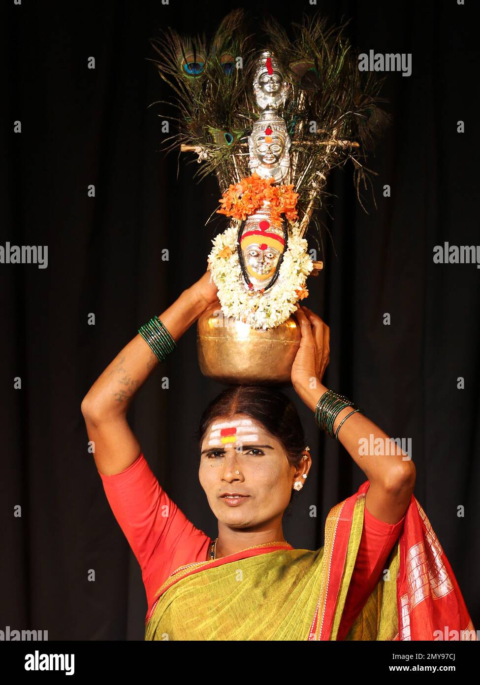 An Indian transgender Yelamma Jogathi carries a vessel with images of ...