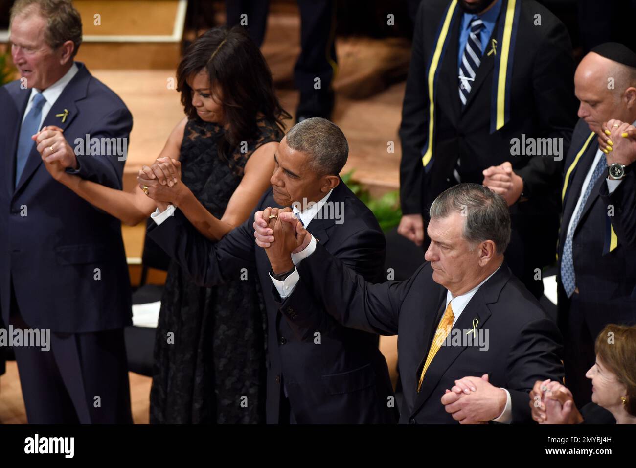President Barack Obama holds hands with Dallas Mayor Mike Rawlings ...