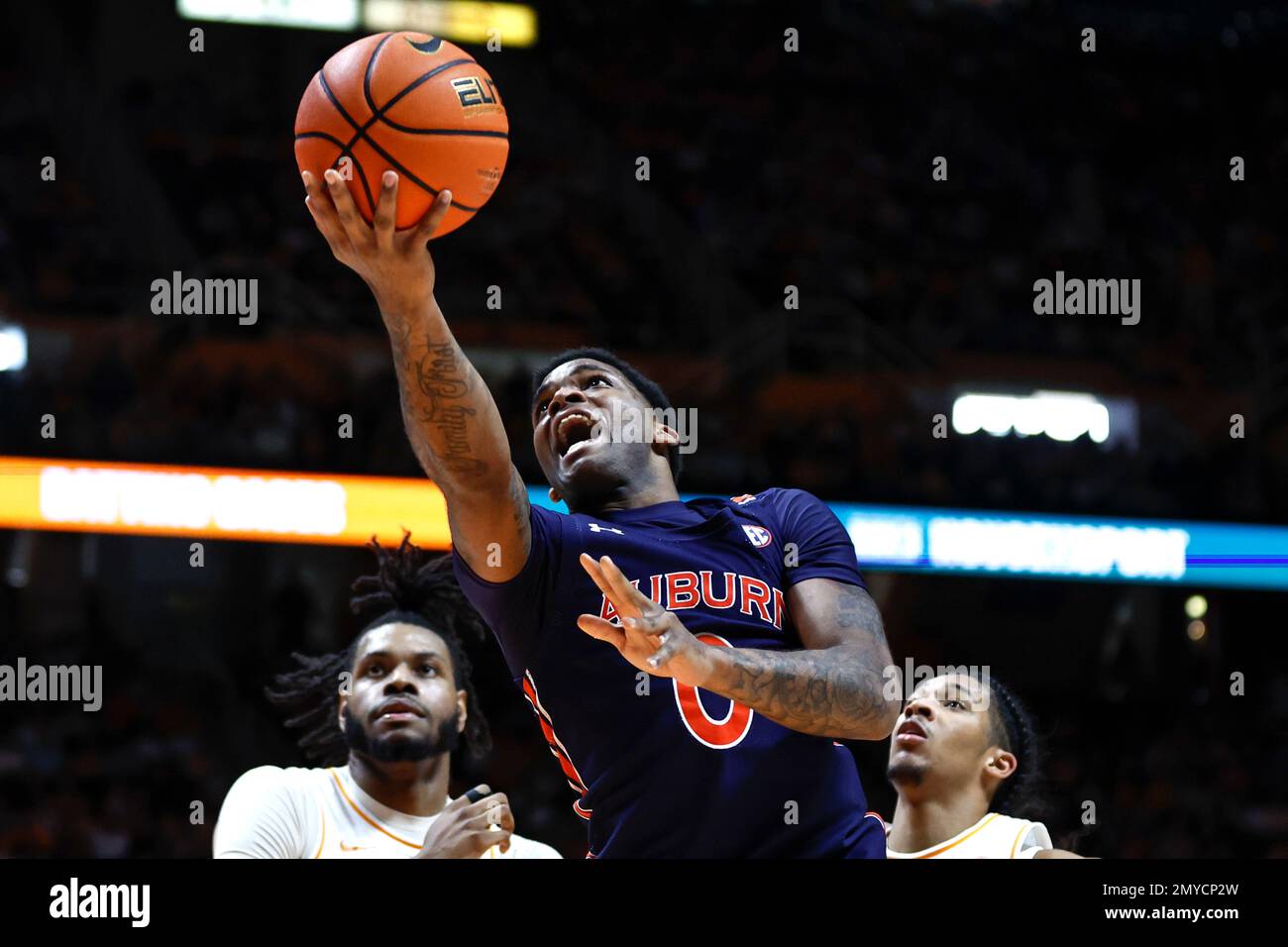 Auburn guard K.D. Johnson (0) shoots past Tennessee guards Zakai ... Auburn guard K.D. Johnson (0) shoots past Tennessee guards Zakai ...