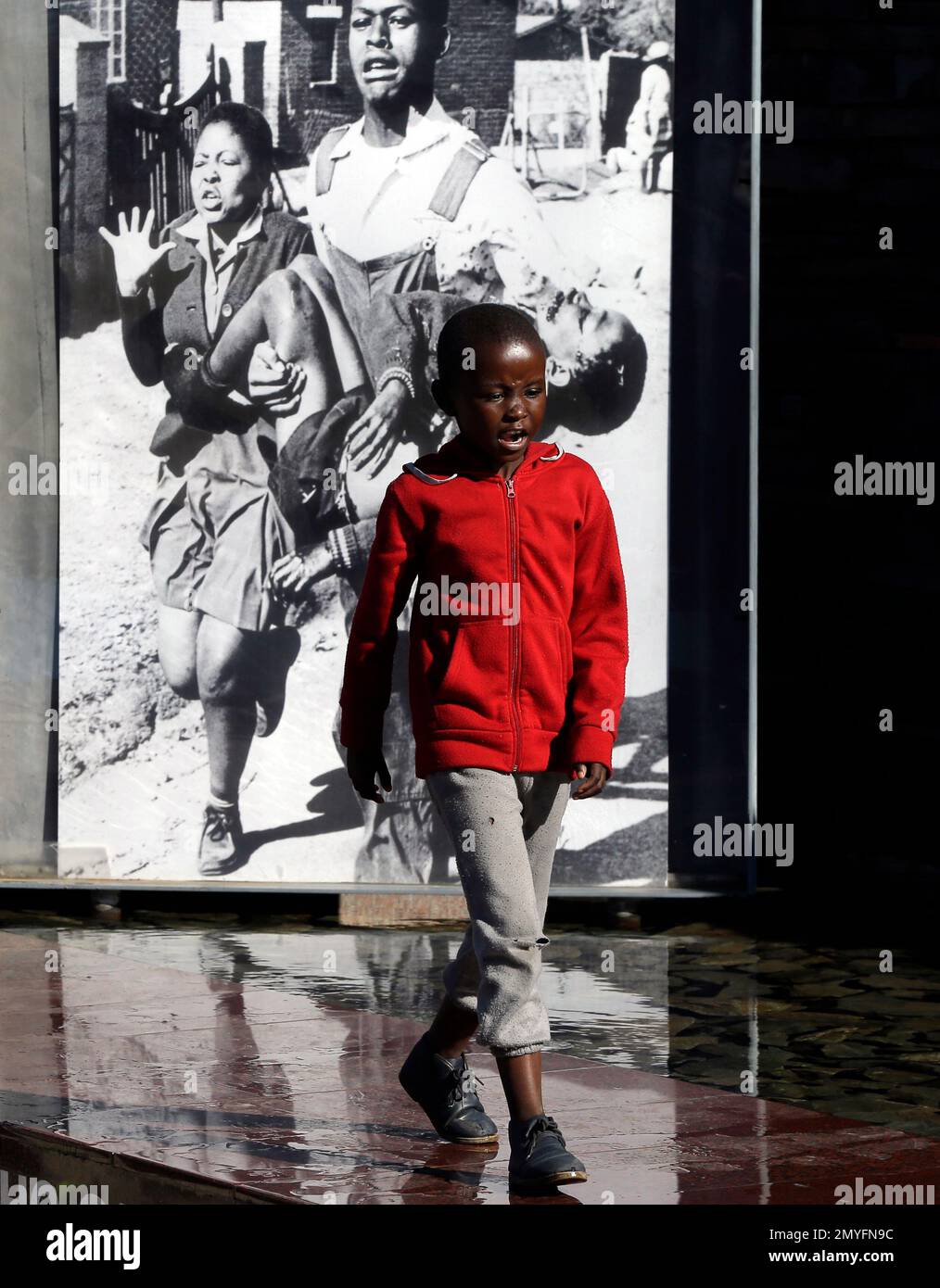 A young boy walks way from a displayed iconic photo showing 13-year-old ...