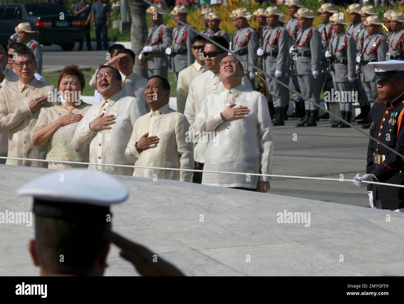 Philippine President Benigno Aquino III, fifth from left, looks up as ...