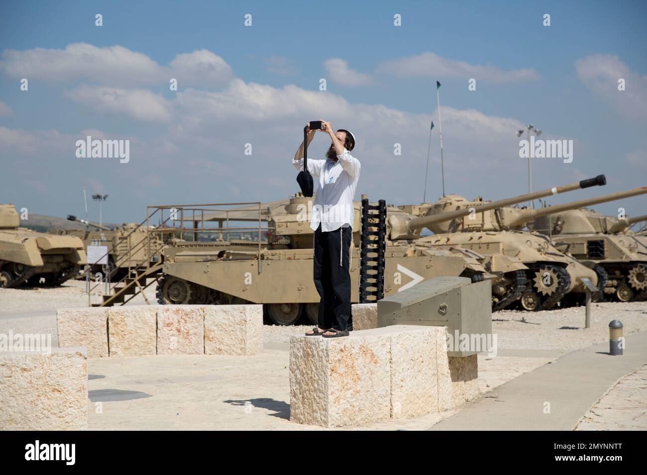 A man takes photos of children sitting on a tank on display at the ...