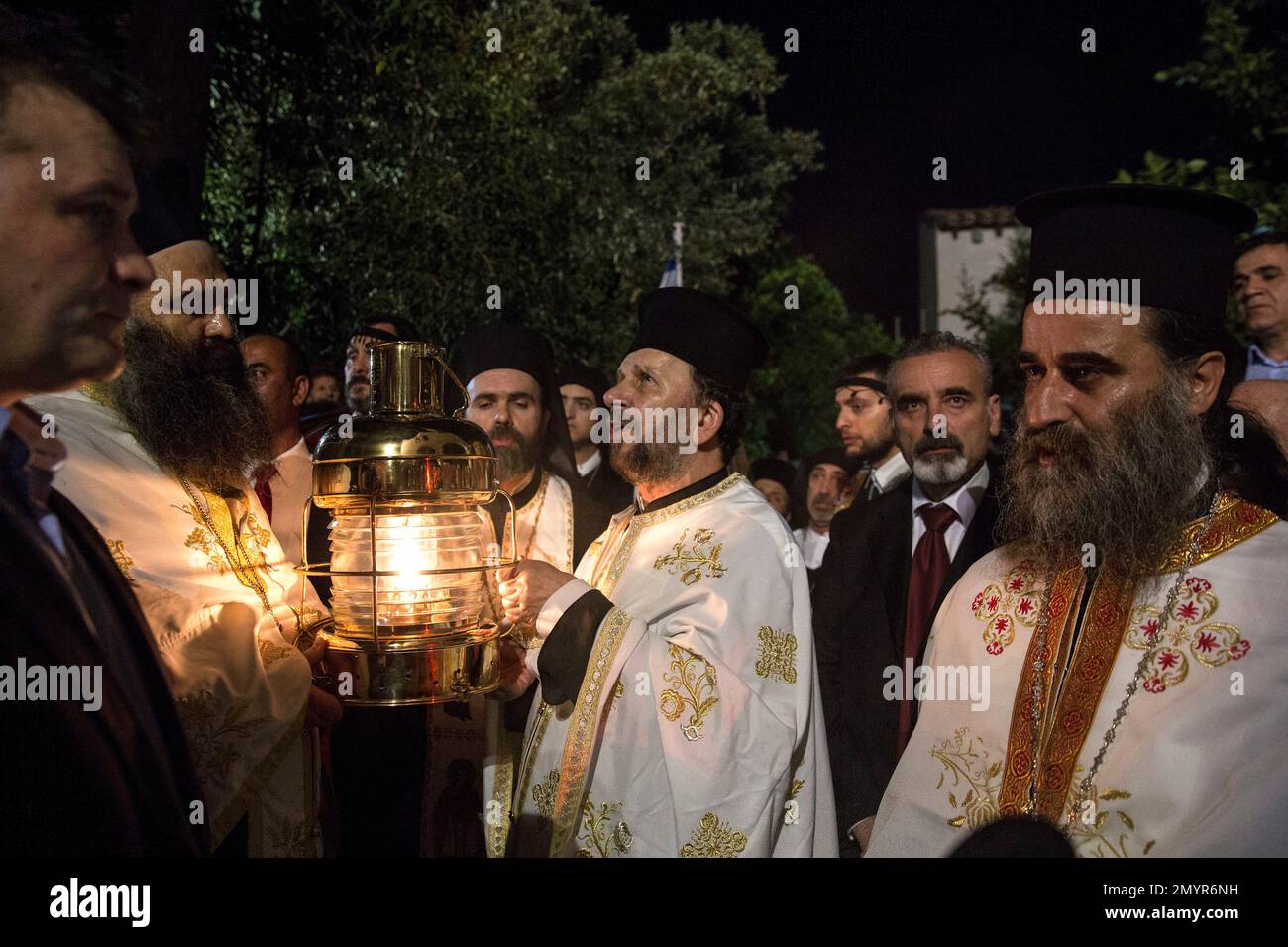 Greek Orthodox priests pray as they carry a lamp with the Holy Fire ...
