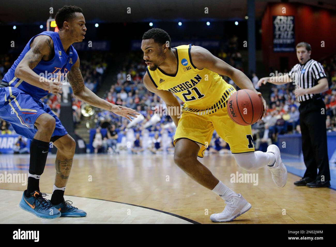 Michigan's Zak Irvin (21) drives against Tulsa's Pat Birt (11) during ...