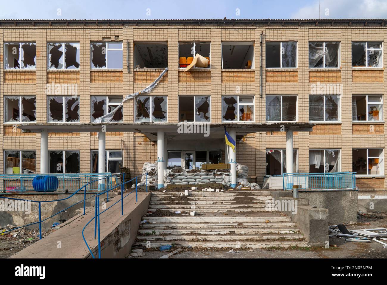 Eintritt in eine Schule, zerstört durch Beschuss. Krieg in der Ukraine. Russische Invasion der ...