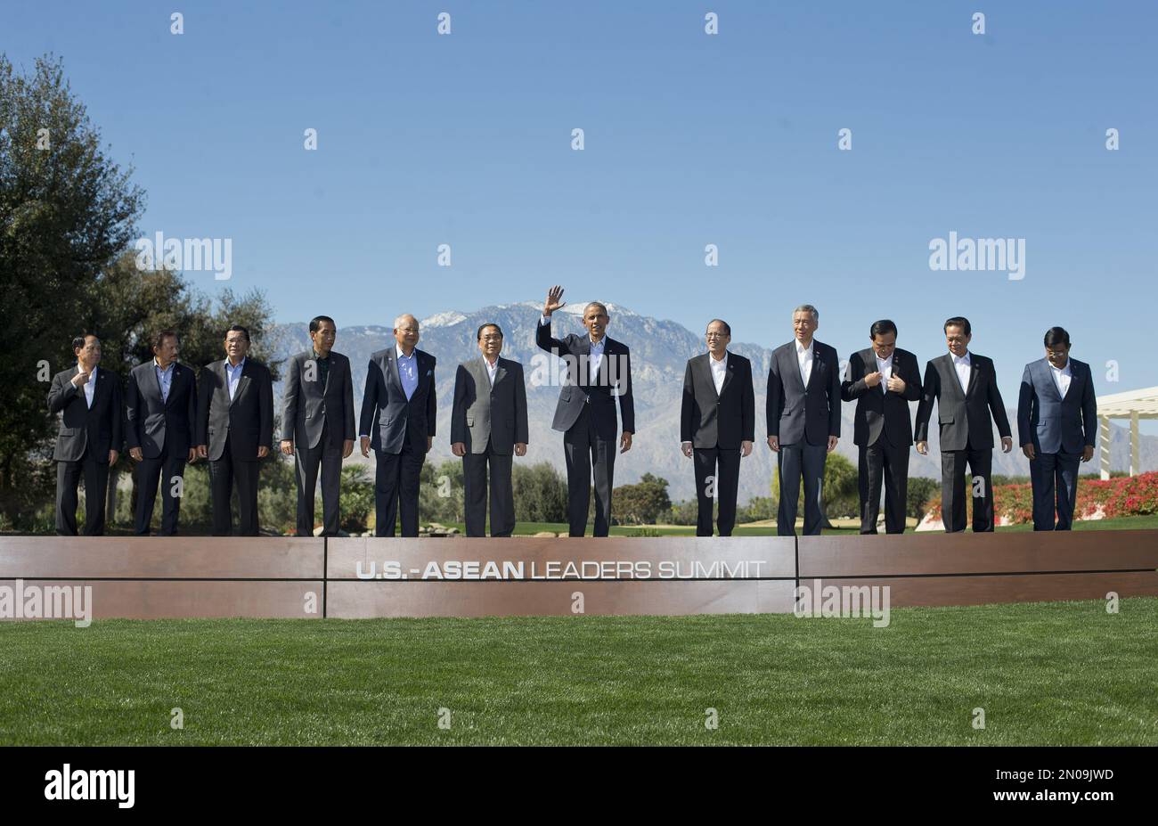 President Barack Obama, center, waves as he poses for a group photo ...