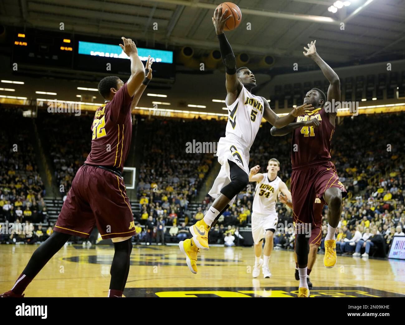 Iowa guard Anthony Clemmons, center, drives to the basket between ...