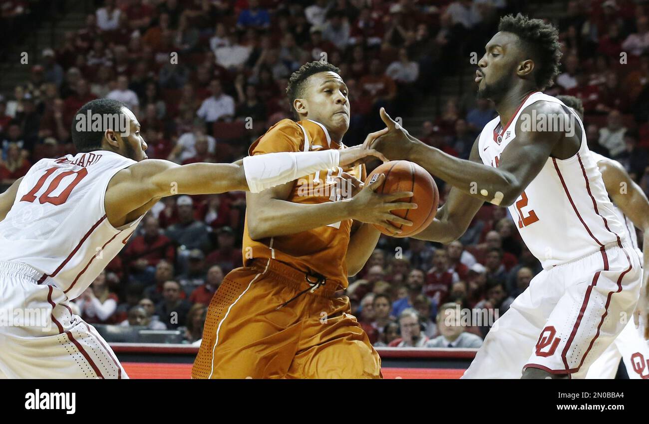 Texas guard Demarcus Holland, center, drives between Oklahoma guard ...