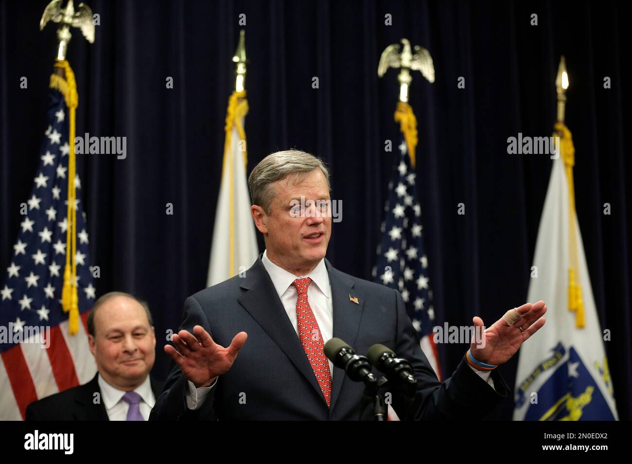 Massachusetts Gov. CharlieBaker, right, faces reporters as Mass. Senate ...