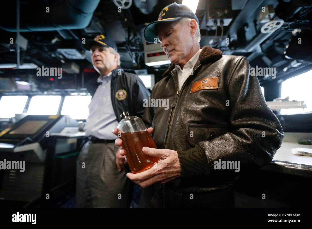 Navy Secretary Ray Mabus, right, holds a sample of a fuel blend ...