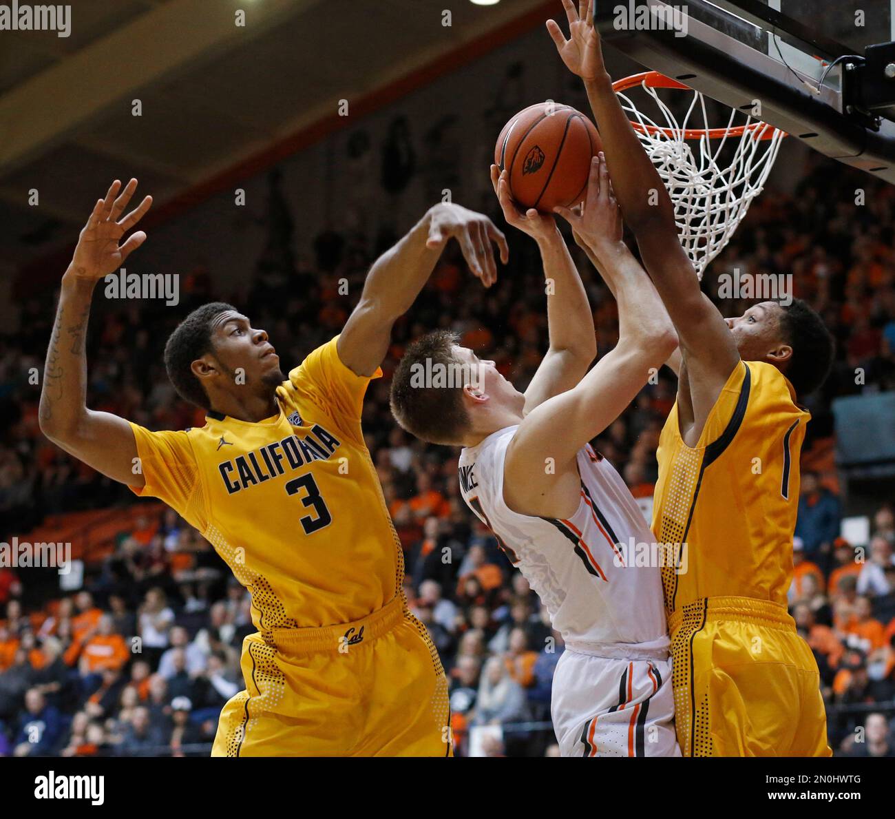 Oregon State's Tres Tinkle, center, tries to get to the basket past ...