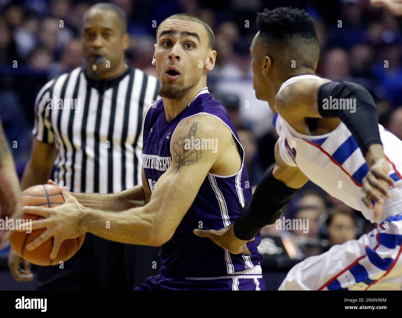 Northwestern guard Tre Demps, left, looks to pass against DePaul guard ...