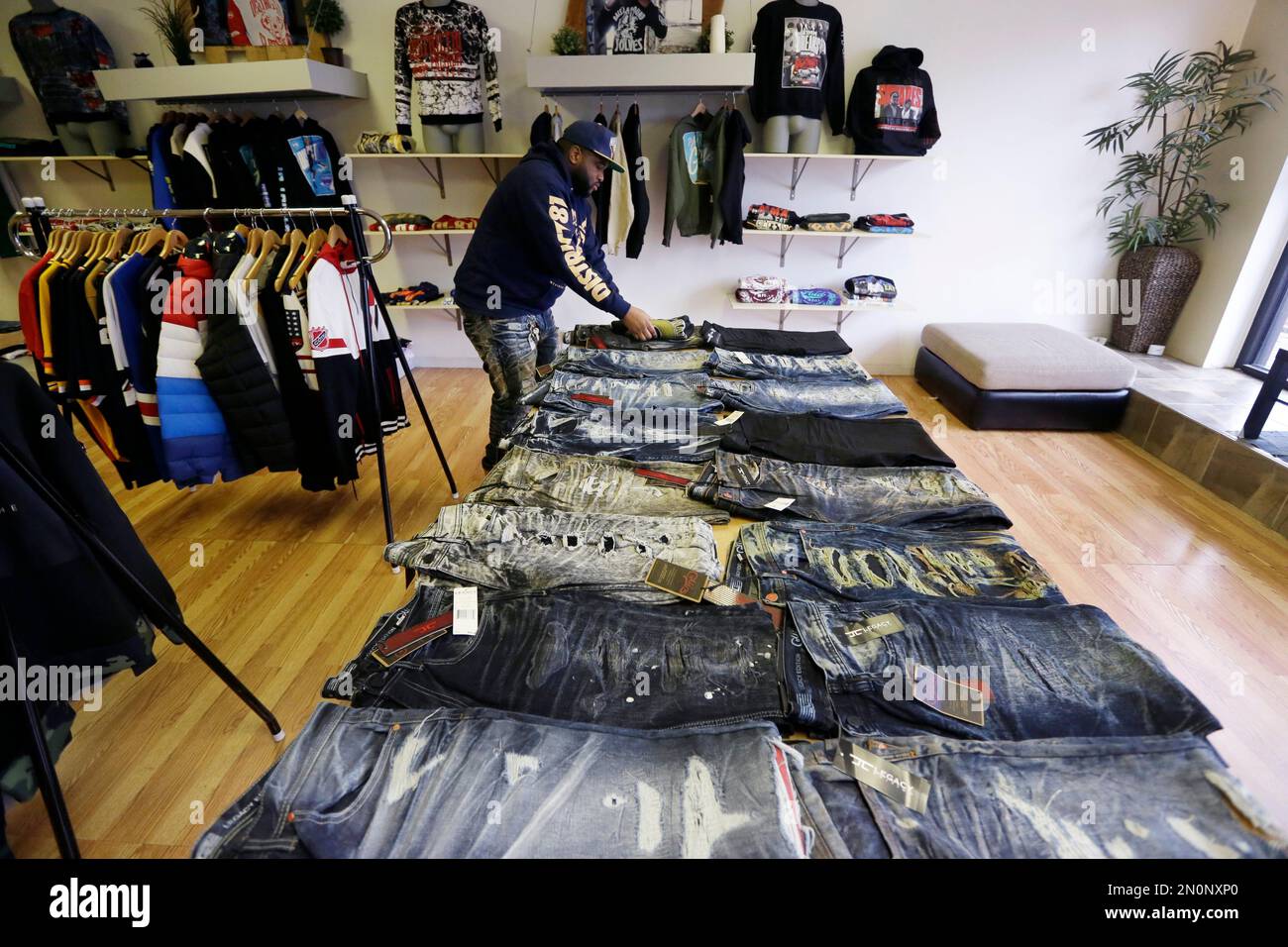 Derek Cain of Flagship, a clothing store, arranges his merchandise ...
