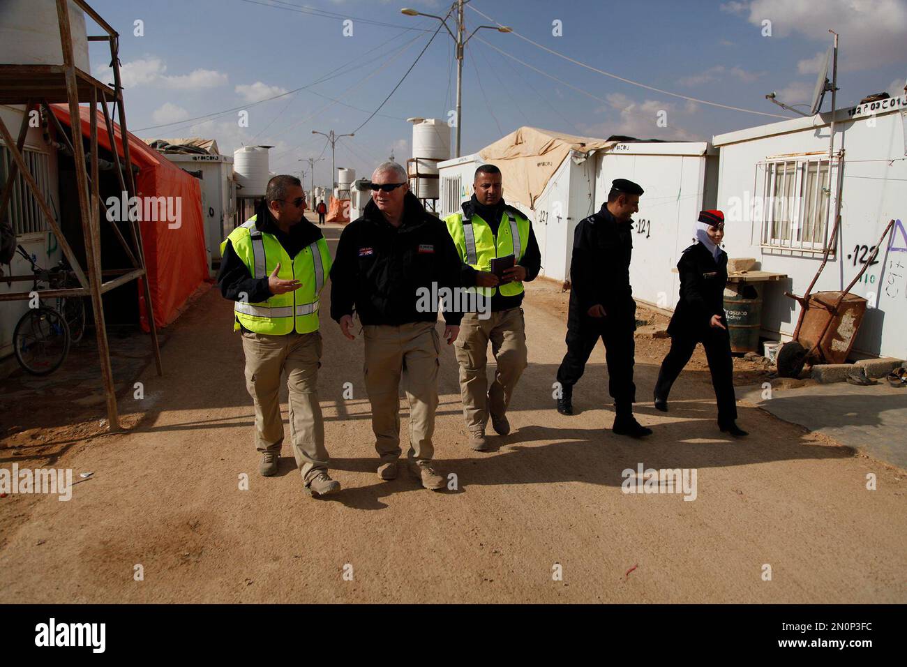 ?A new community police patrol walks down a road in Zaatari refugee ...