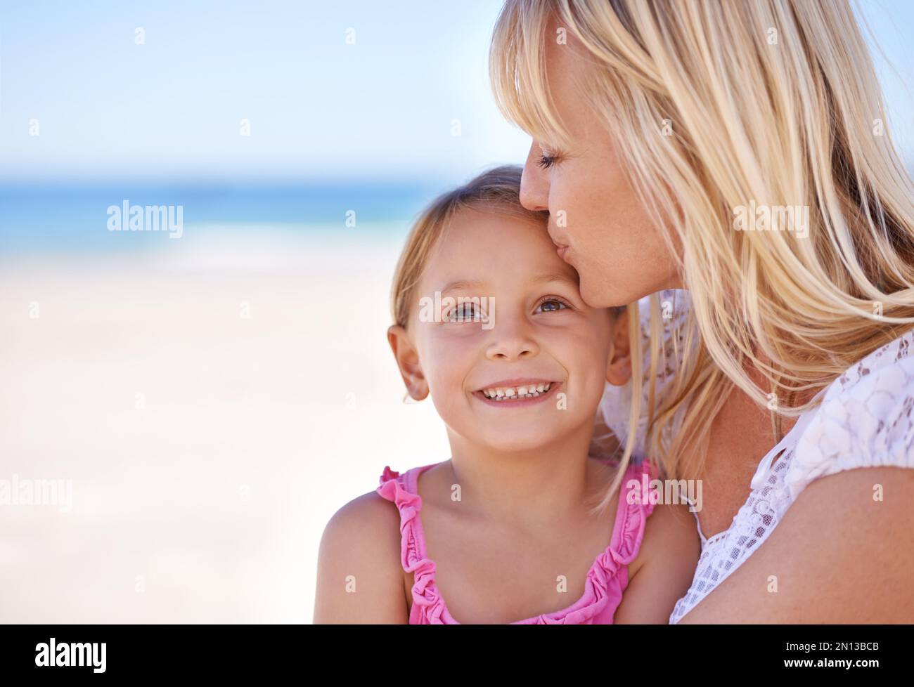 Ihr kleiner Strandengel. Eine Mutter, die ihrer Tochter am Strand einen ...