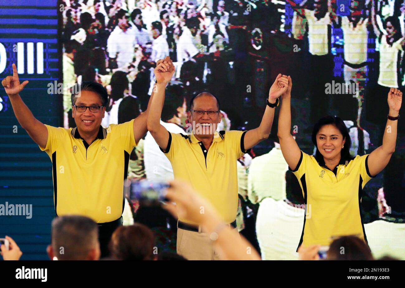 Philippine President Benigno Aquino III, center, raises the hands of ...